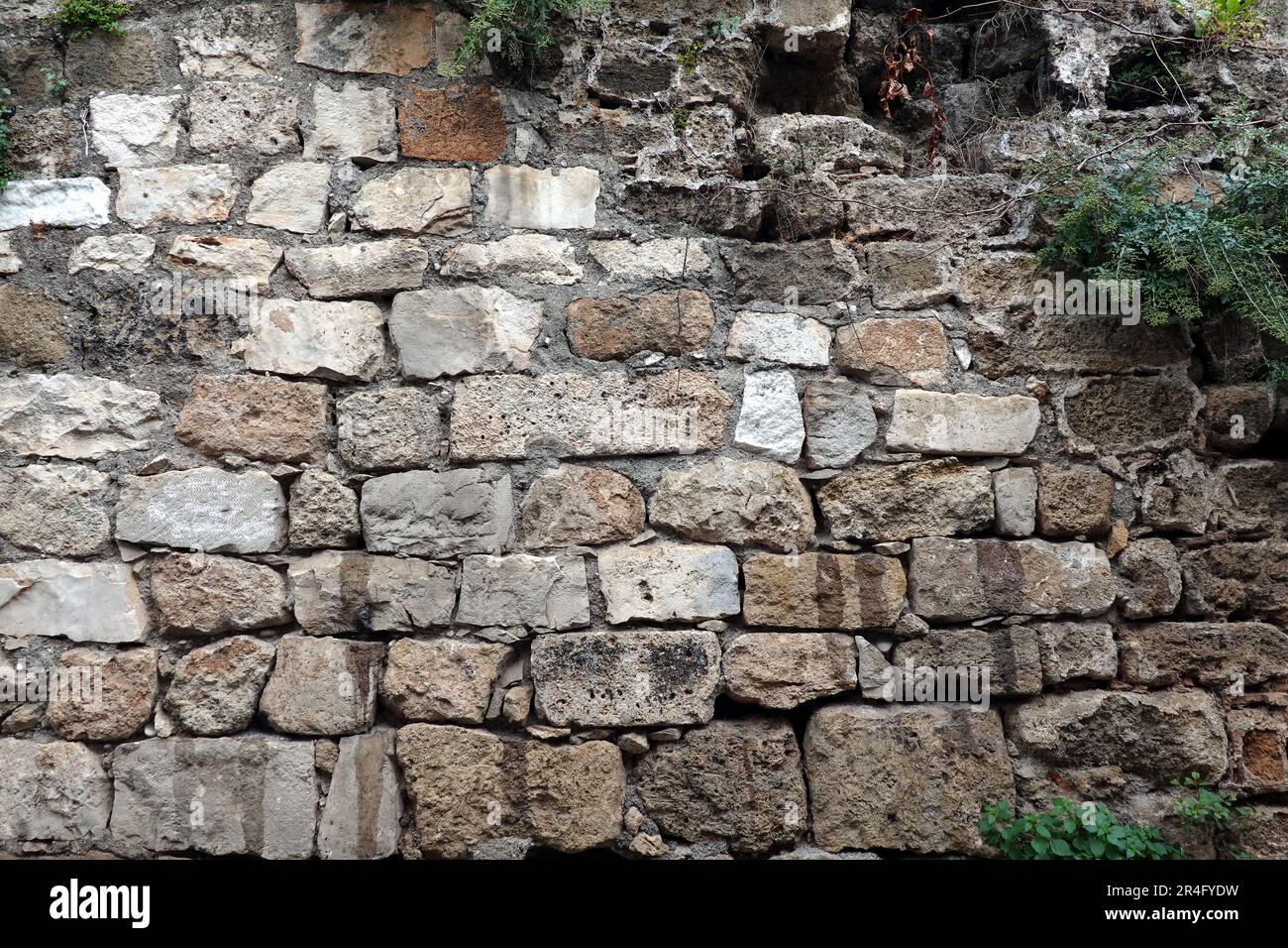 Old stonework from old natural stones as a background with vegetation ...