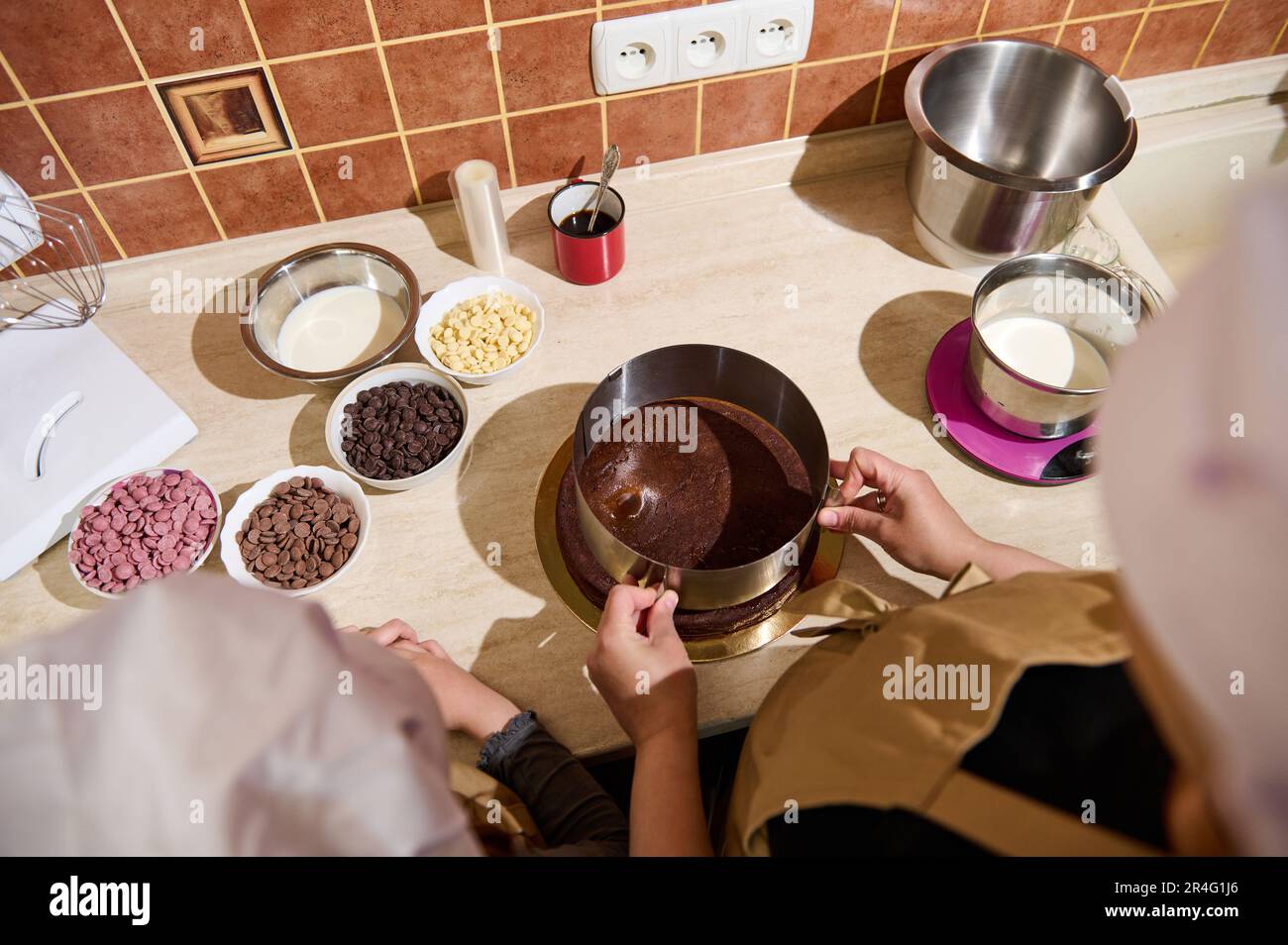 Top view of female chef confectioner putting a baked biscuit inside a ...
