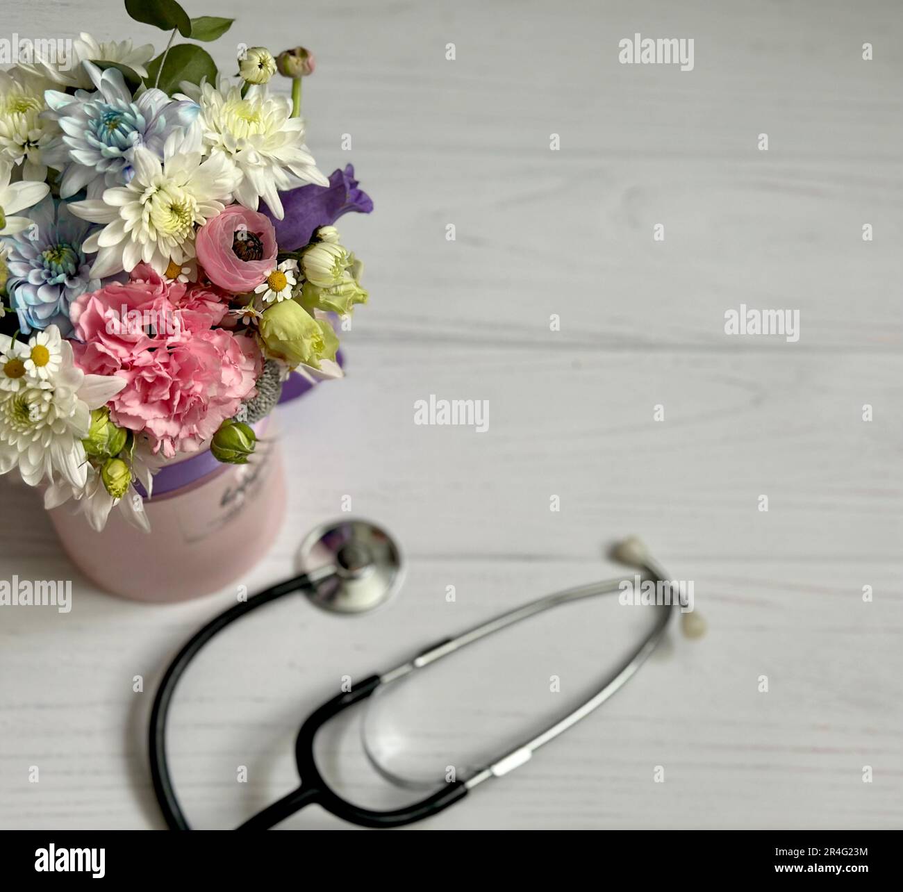 Stethoscope and beautiful flowers on the light wooden background ...