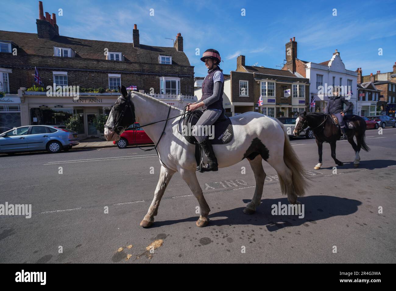 London UK. 28 May 2023 Horse riders pass through Wimbledon village in ...