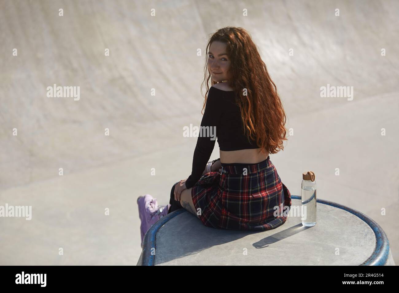 Young inline roller blader female posing in a skate pool. Portrait of a ...