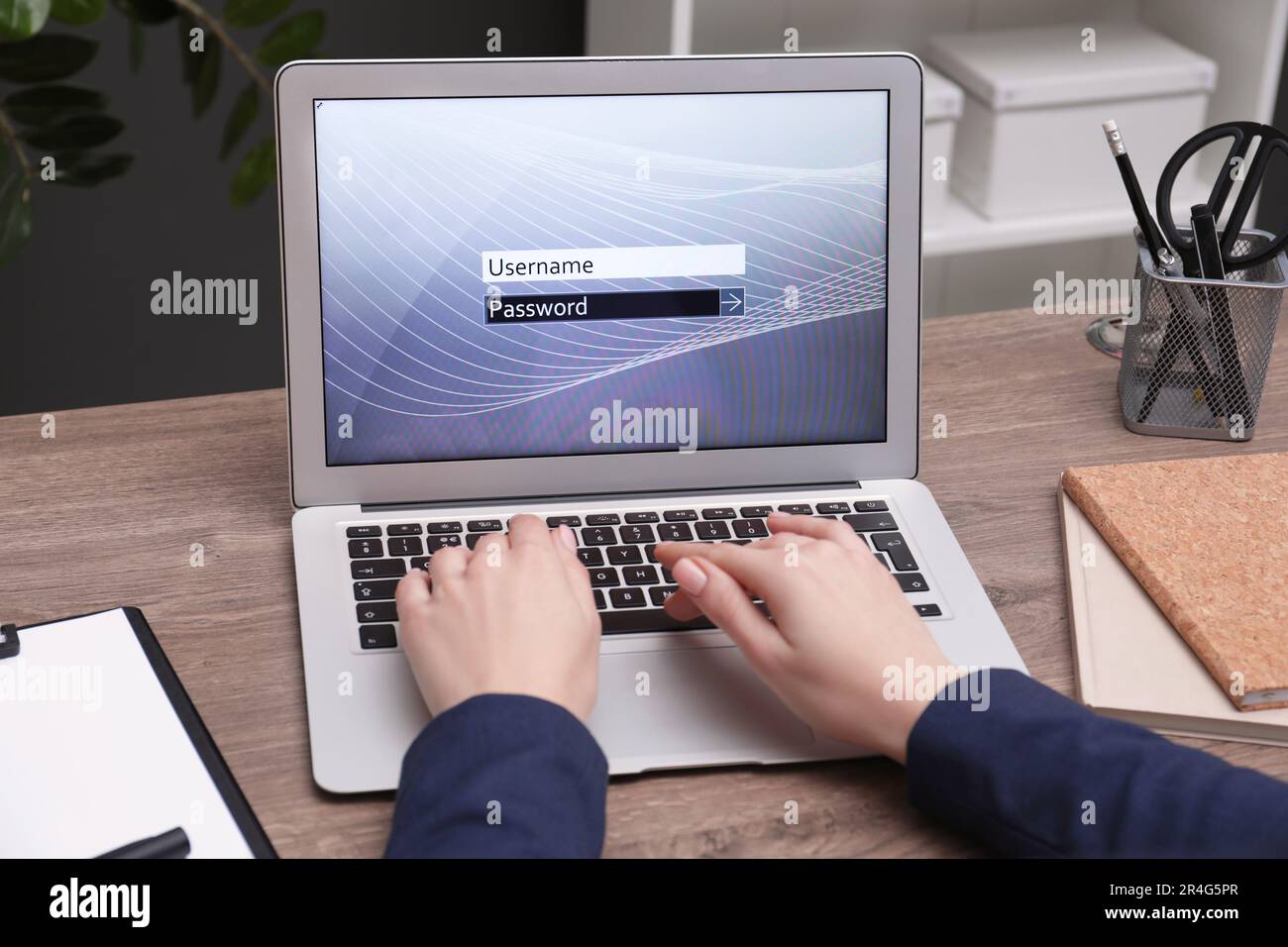 Woman unlocking laptop with blocked screen at wooden table indoors ...