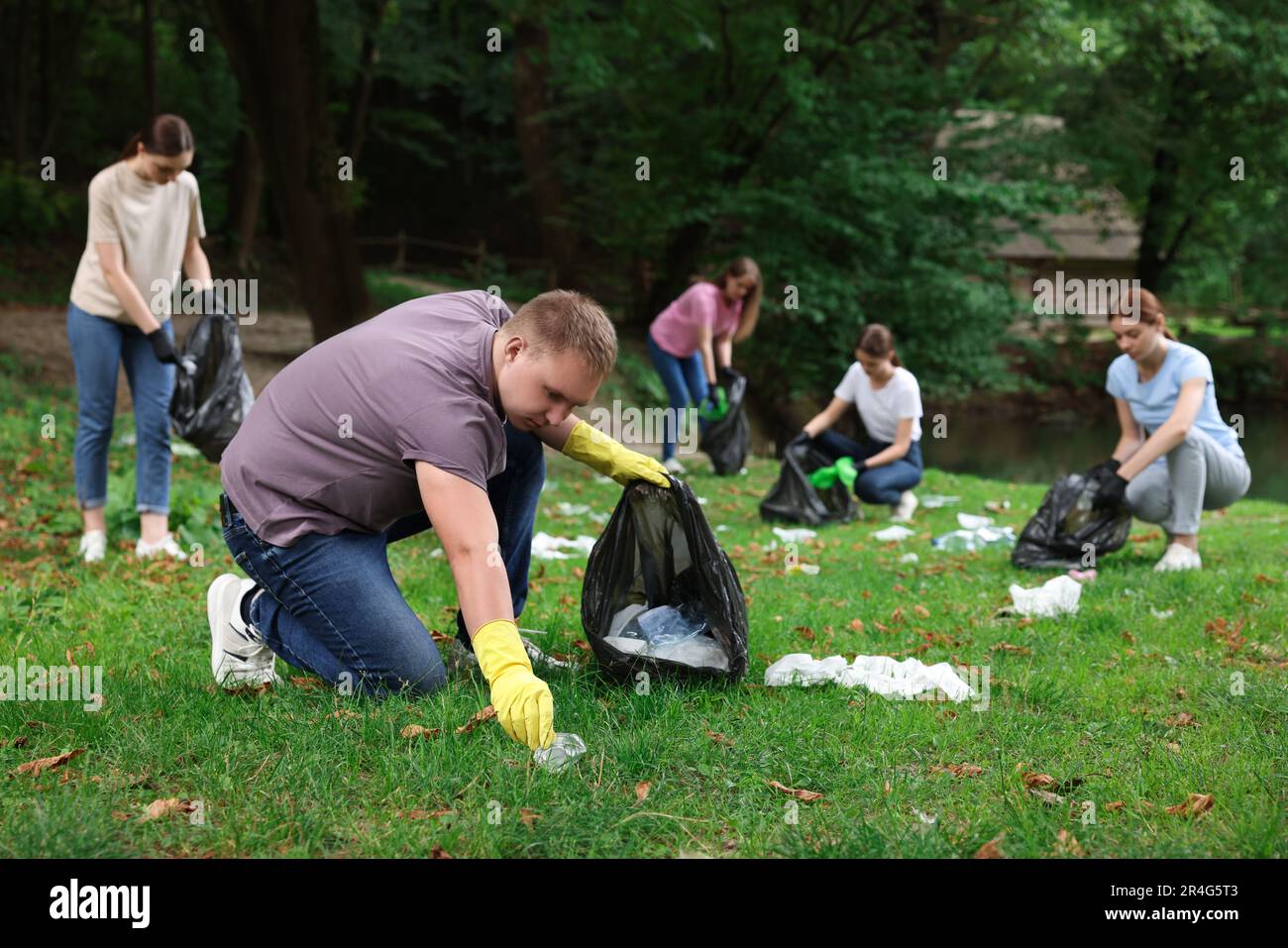 Group of people with plastic bags collecting garbage in park Stock ...
