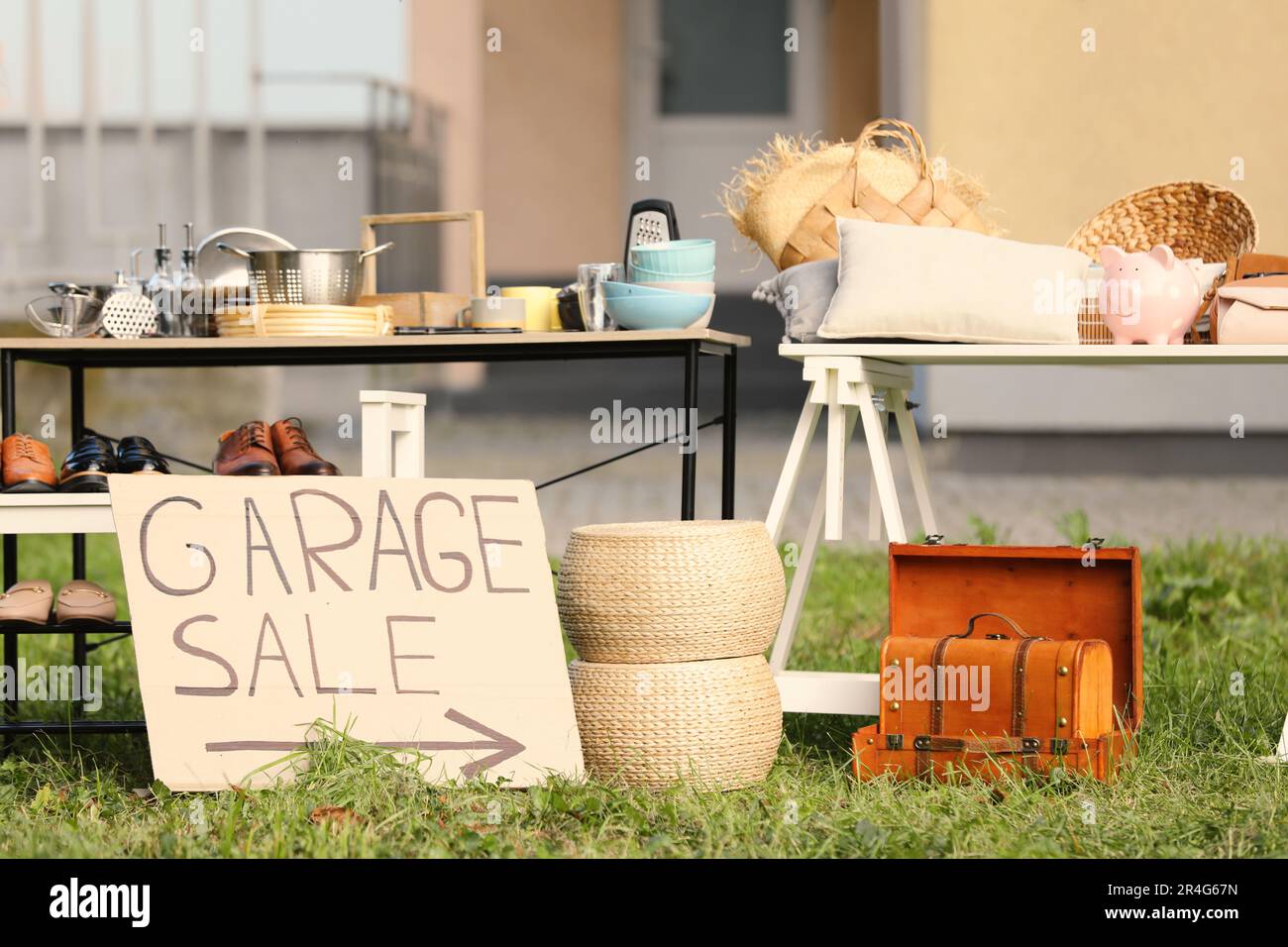 Sign Garage sale written on cardboard near tables with different stuff ...