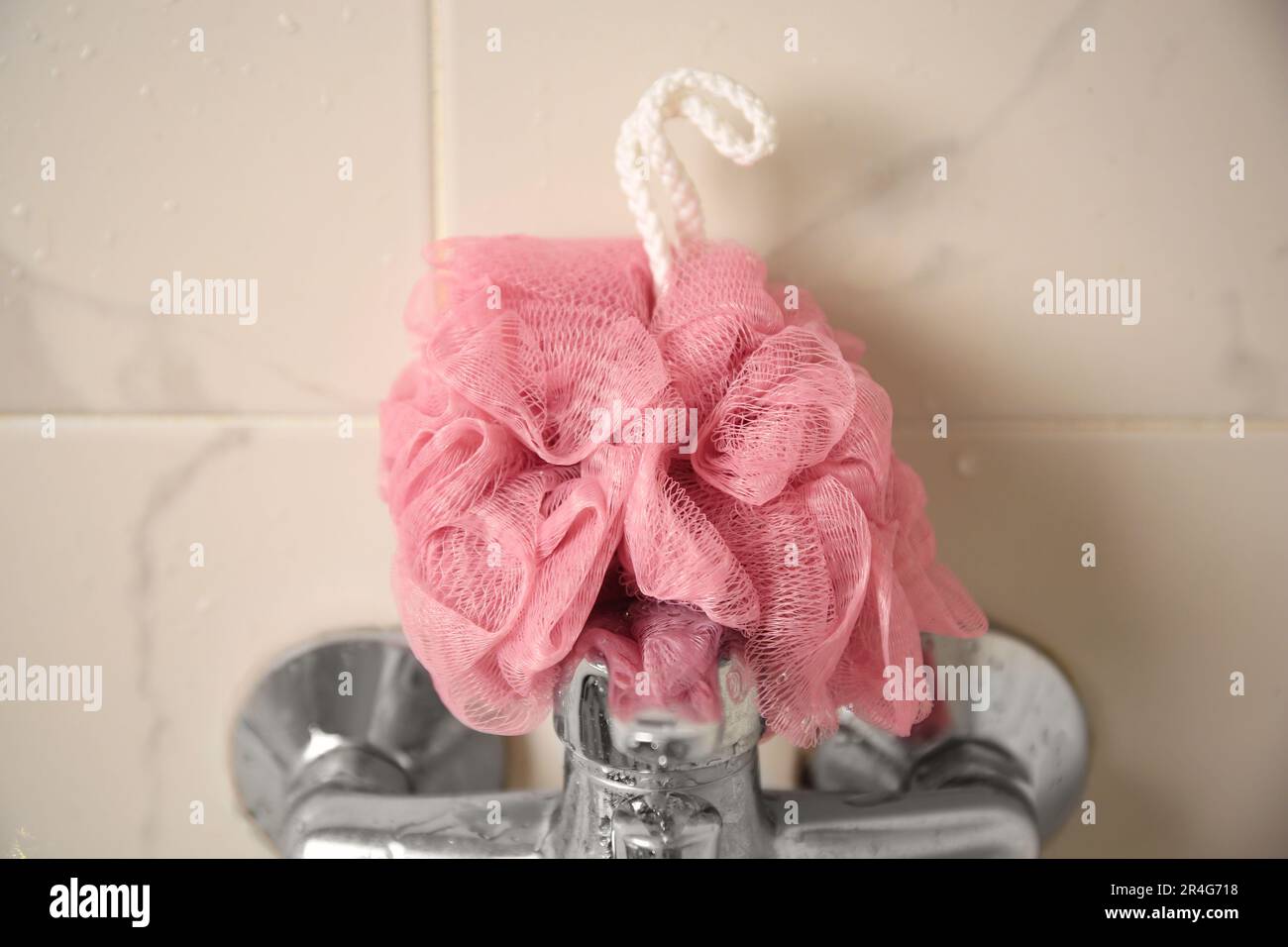 Pink shower puff on faucet in bathroom, closeup Stock Photo - Alamy