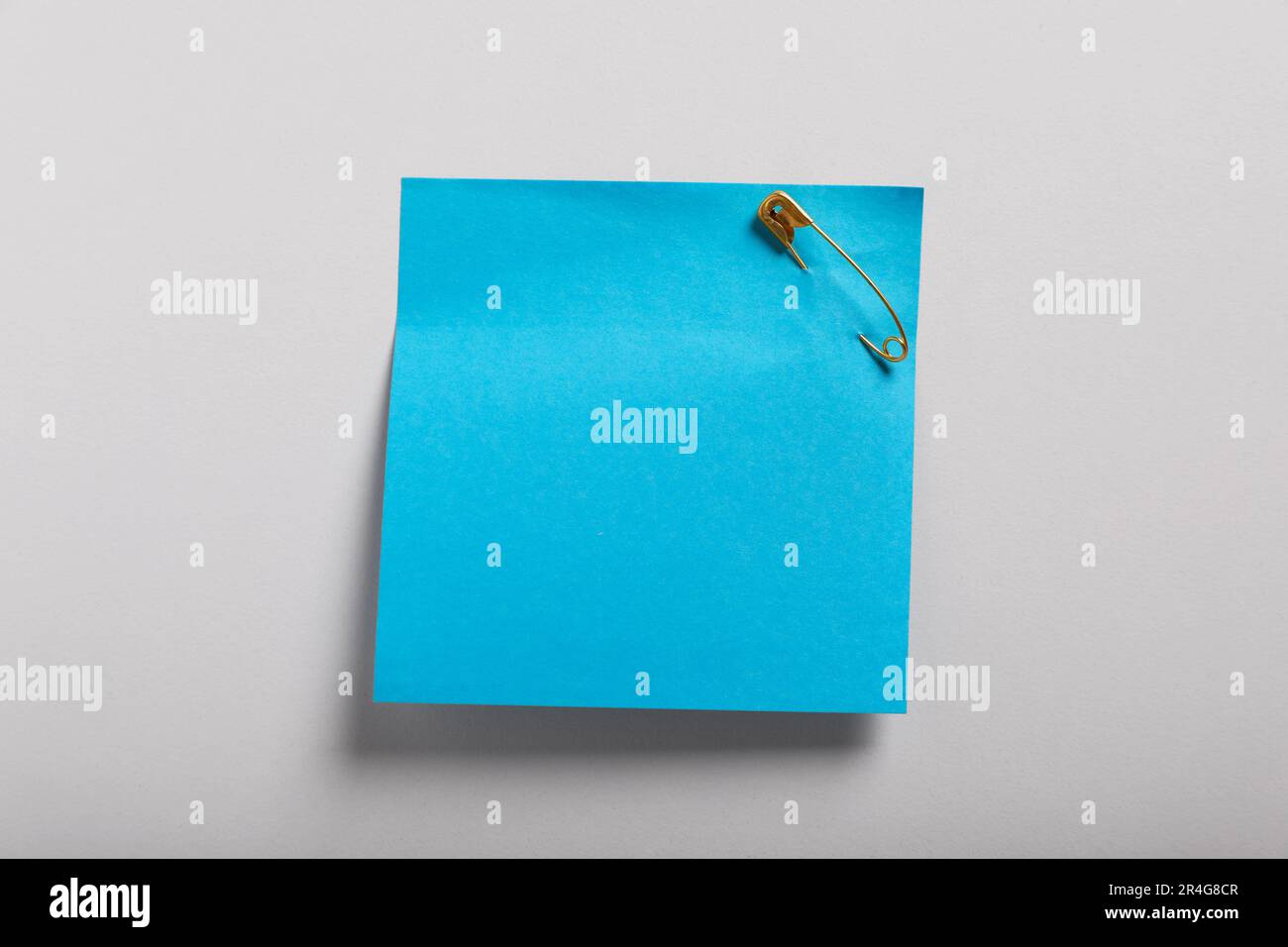Blue paper note attached with safety pin on white background Stock ...