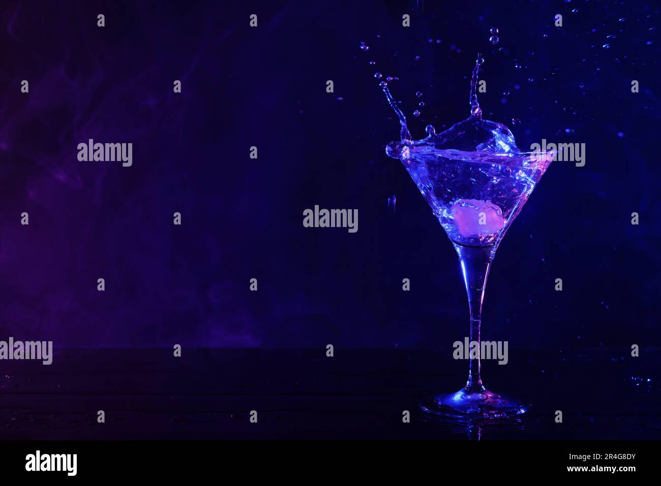 Martini splashing out of glass in neon lights, space for text Stock ...