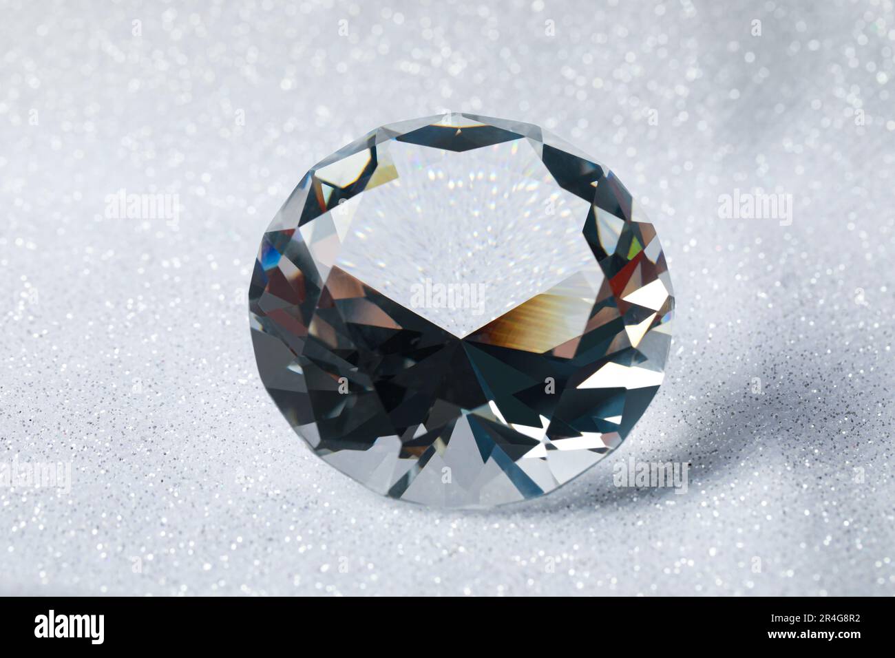 Beautiful dazzling diamond on shiny glitter background, closeup ...