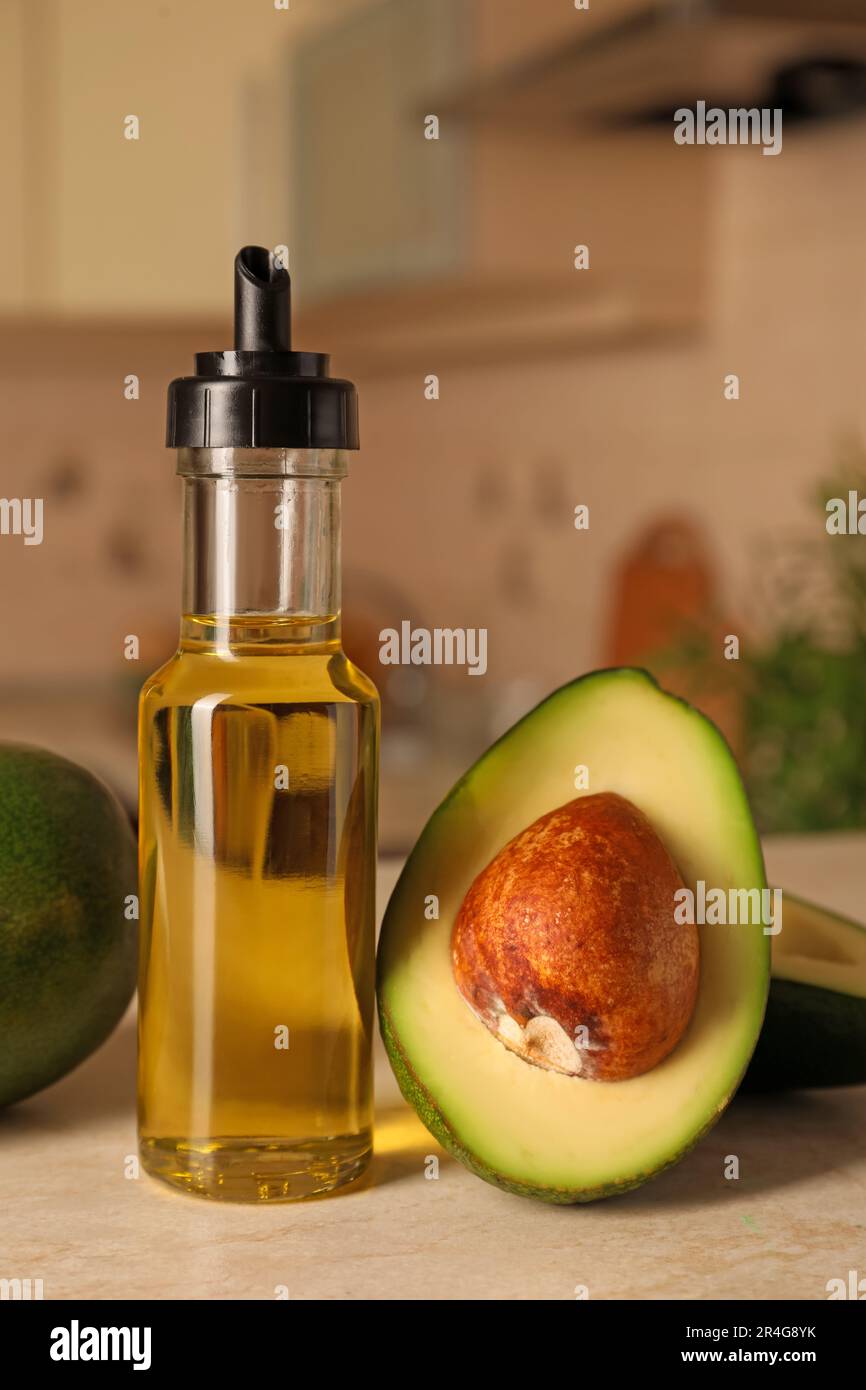 Fresh avocados and cooking oil on beige marble table in kitchen Stock ...