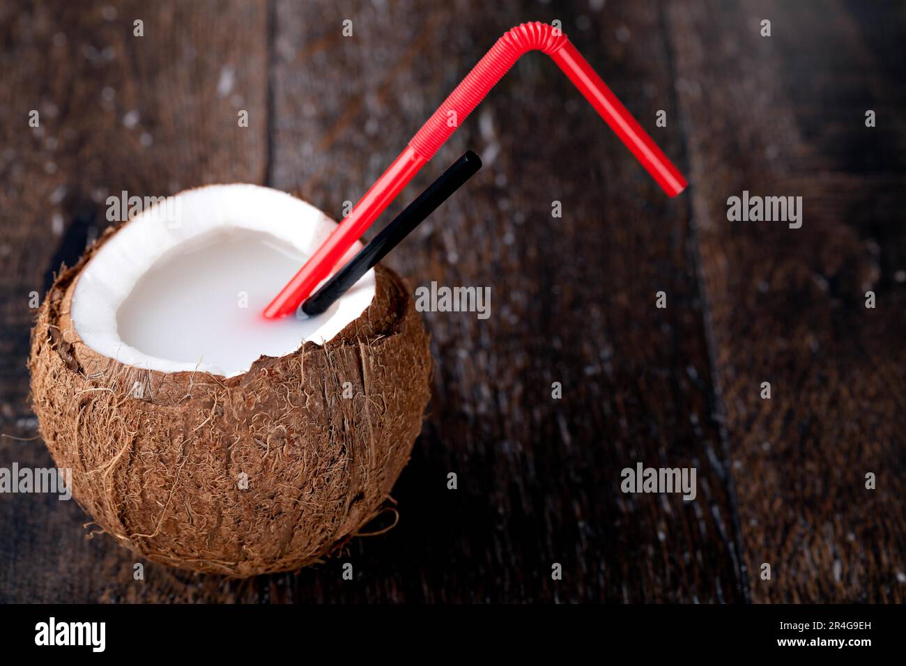 Coconut cocktail with red straw Stock Photo - Alamy