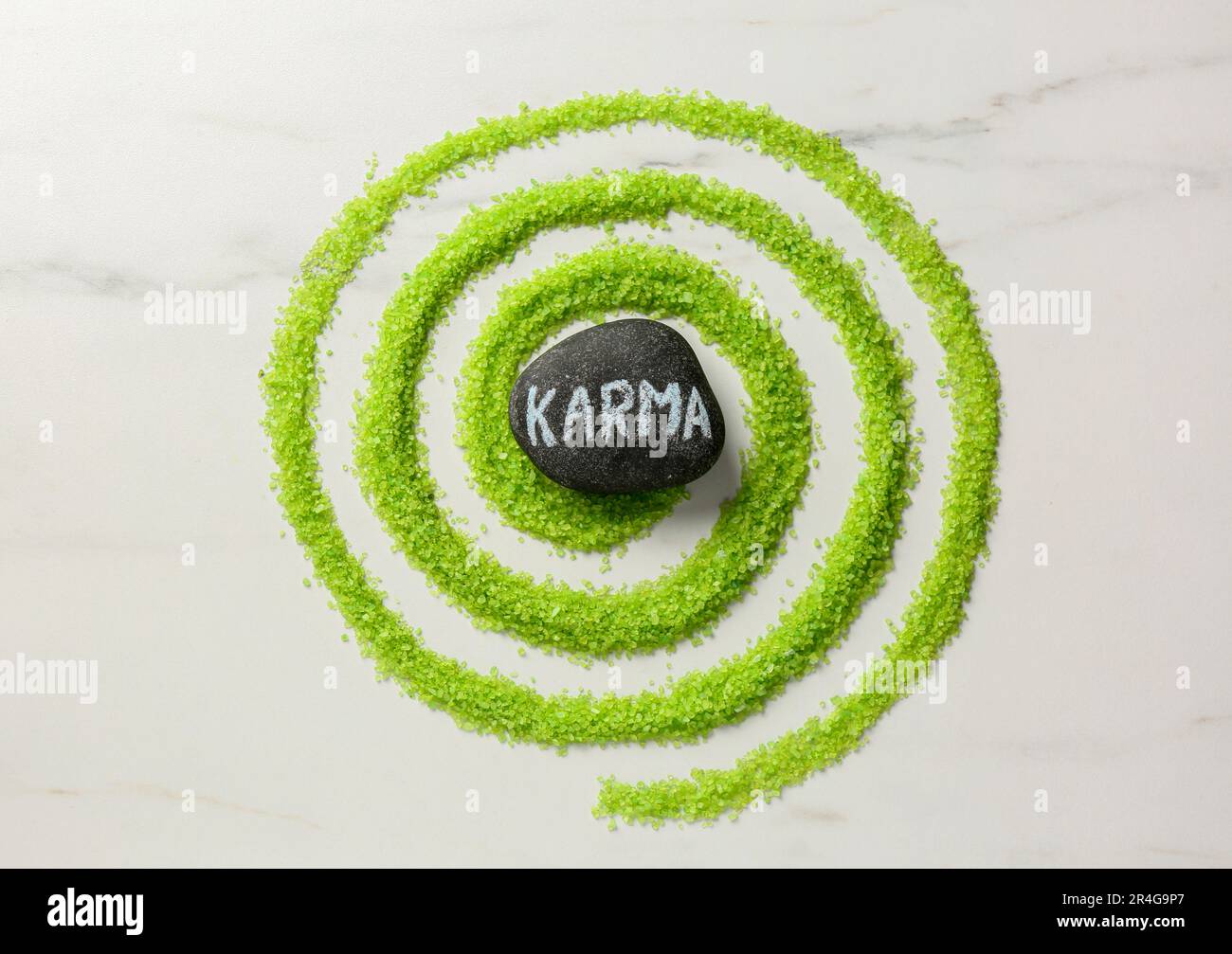 Stone with word Karma and circle made of light green sea salt on white ...