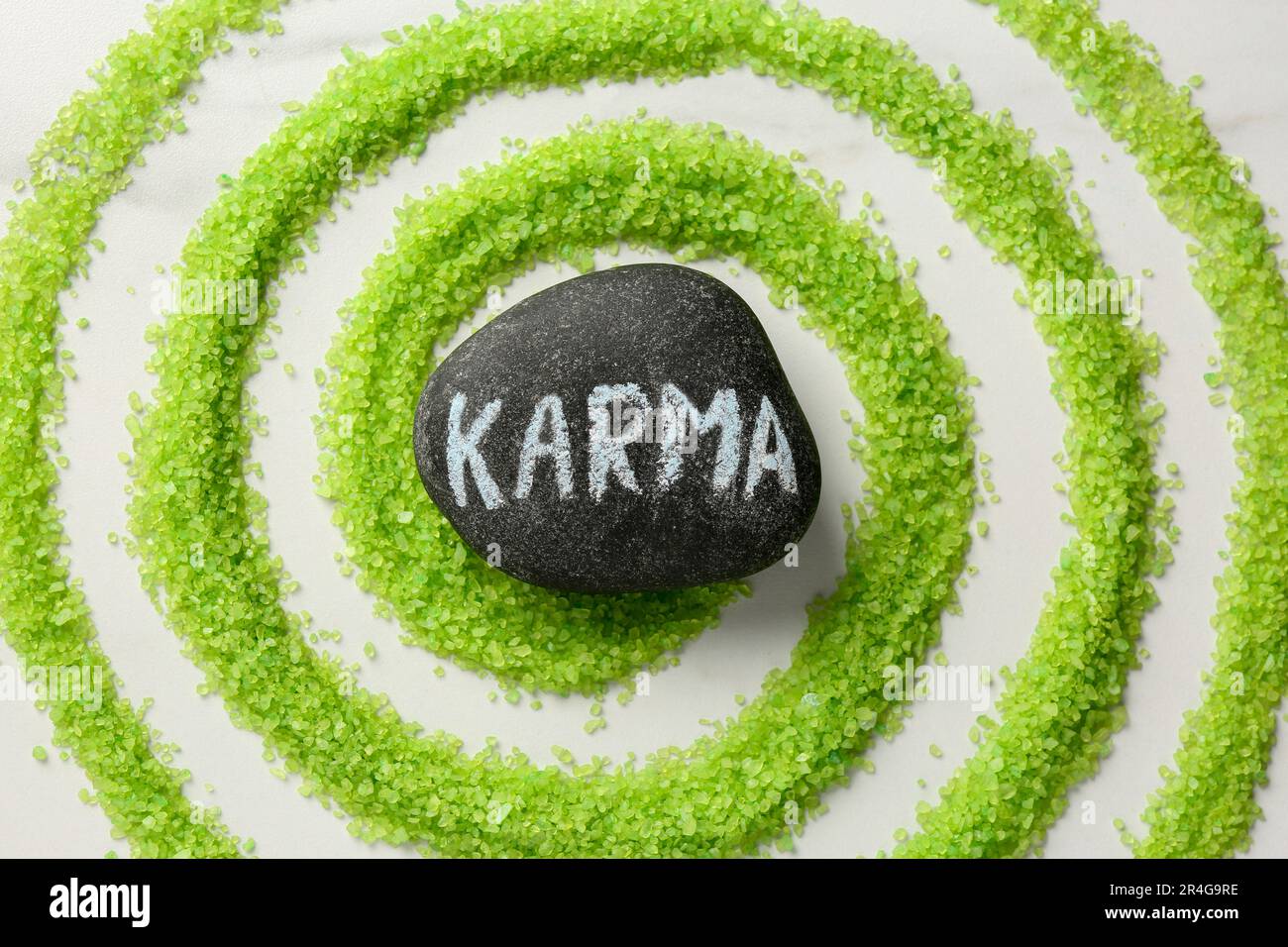 Stone with word Karma and circle made of light green sea salt on white ...