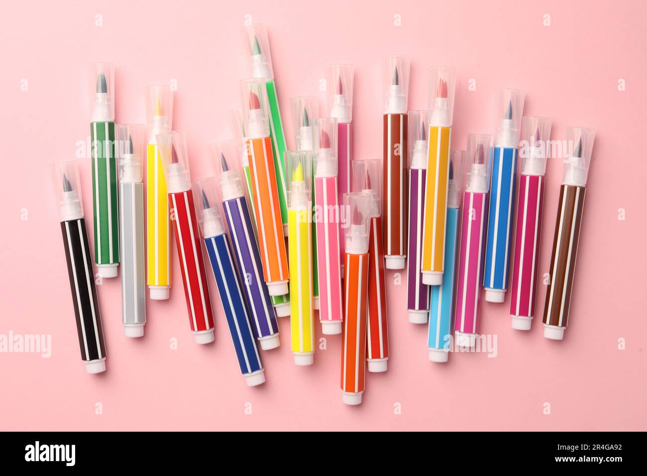 Many bright markers on pink background, flat lay Stock Photo - Alamy