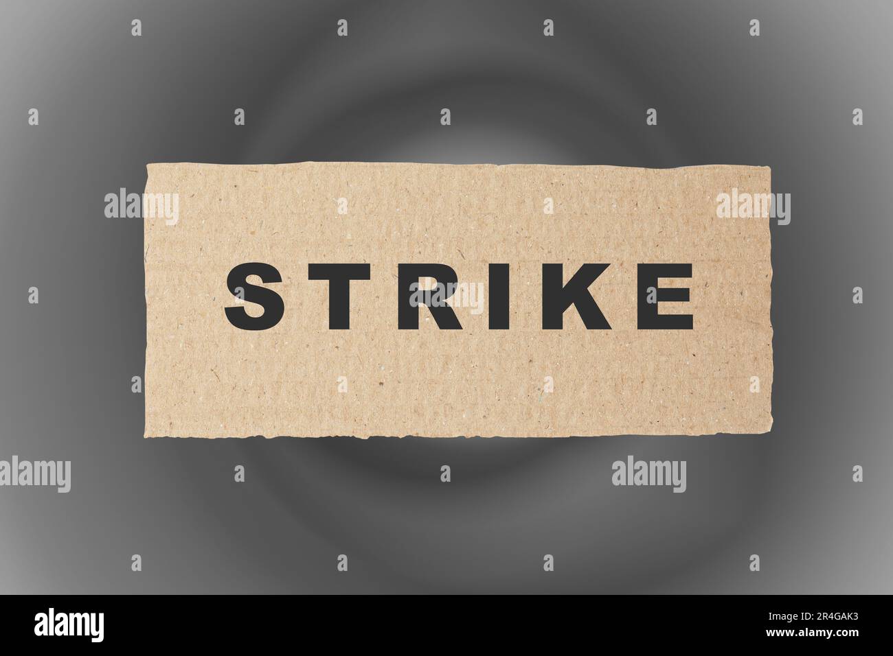 Piece of cardboard with word Strike on abstract grey background Stock ...