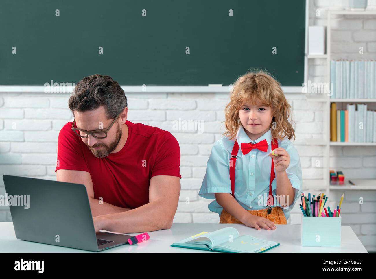 School teacher with a schoolboy. Teacher and students in the classroom ...