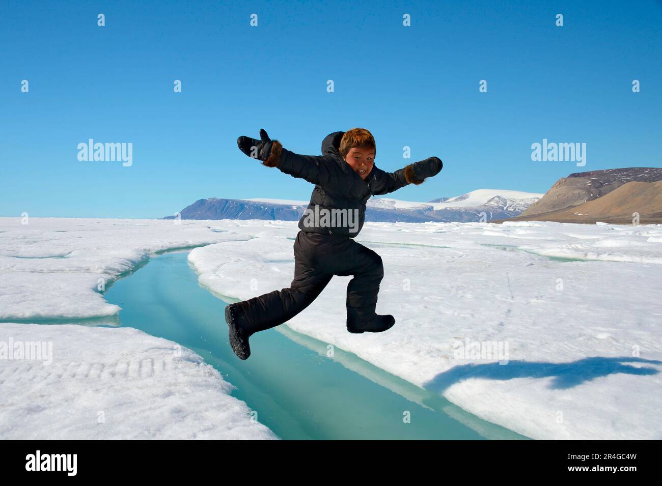 Inuit boy jumps over crevice in ice floe, Ellesmer, Eskimo, Inuit boy ...
