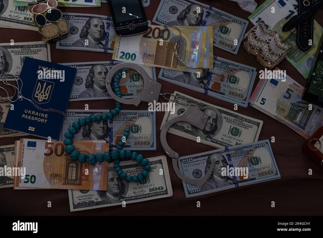 Crime scene, physical evidence. Gun handcuffs, money, dollar on a dark ...