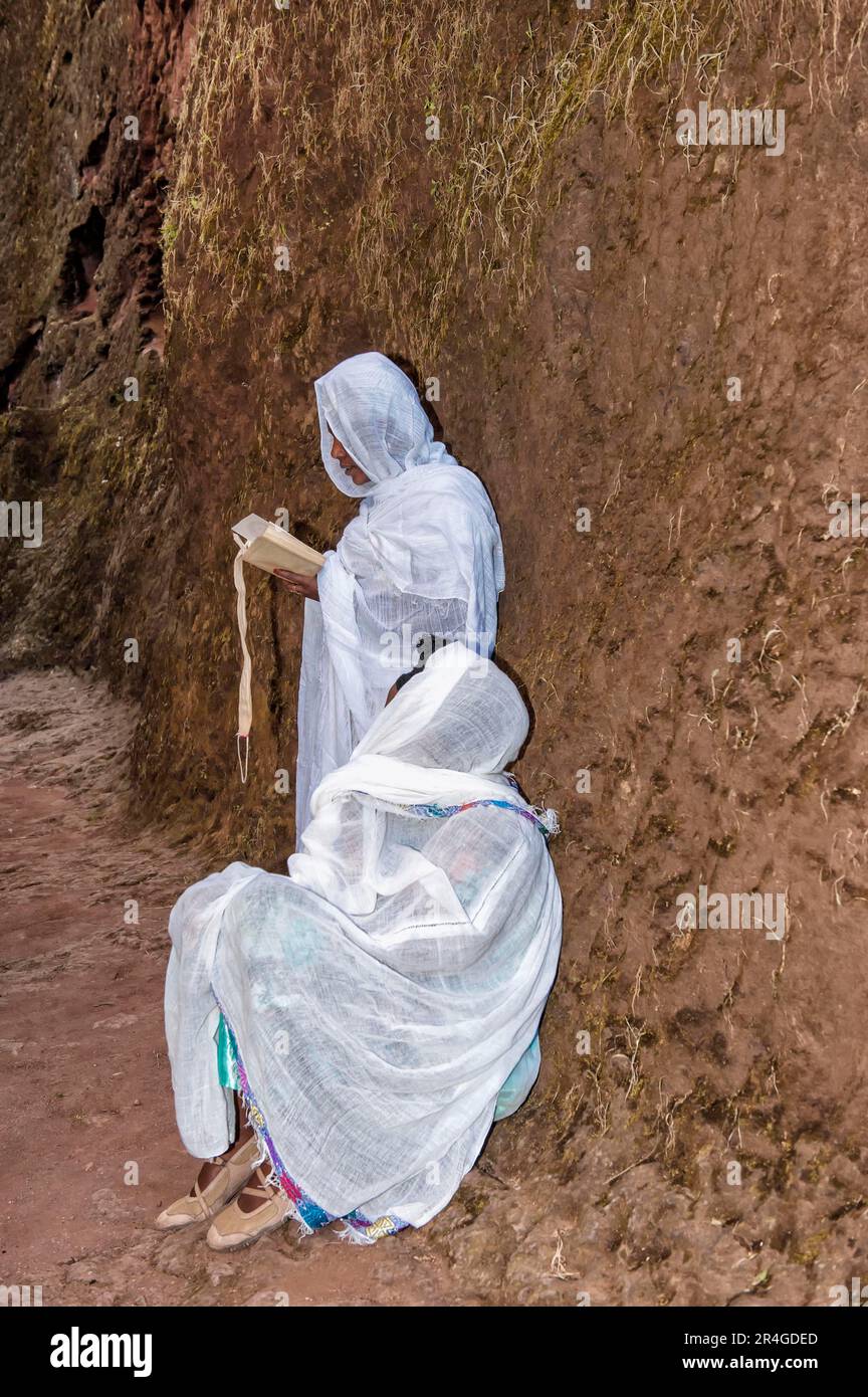 Pilgrim reading bible, rock church, traditional dress, white cloak ...