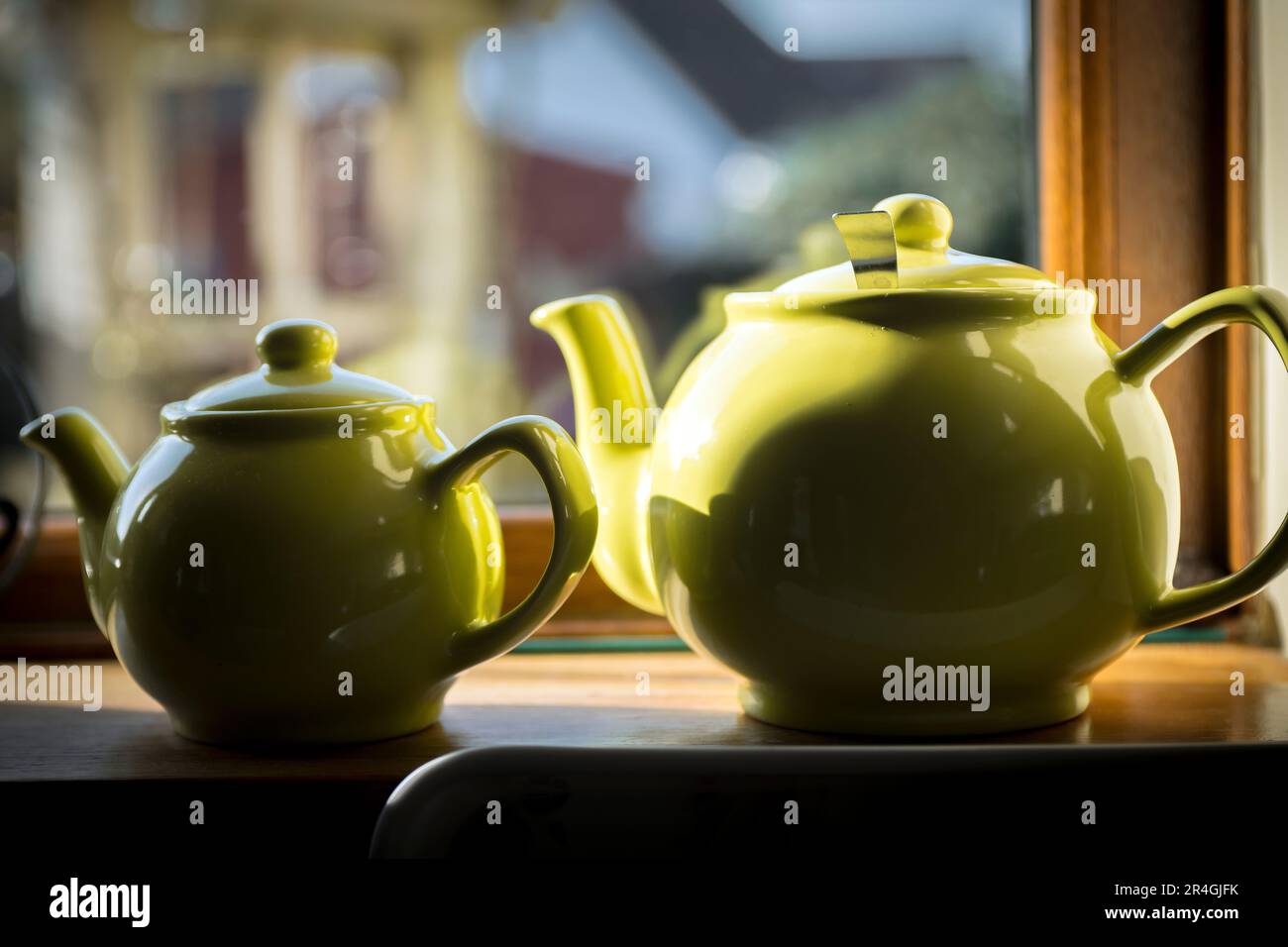 Big and small teapot on the window Stock Photo - Alamy