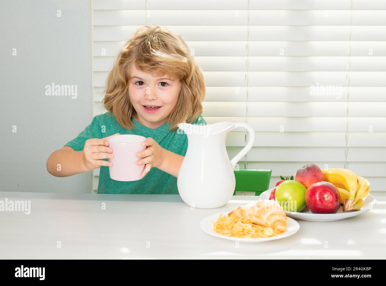 Portrait of preteen child eat fresh healthy food in kitchen at home ...