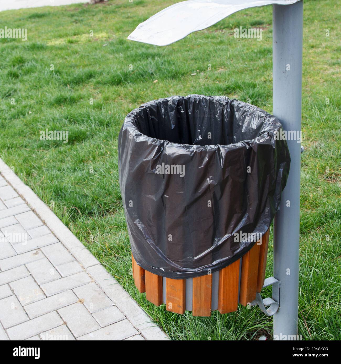 A garbage bin with a garbage bag is installed in a public place, a park ...