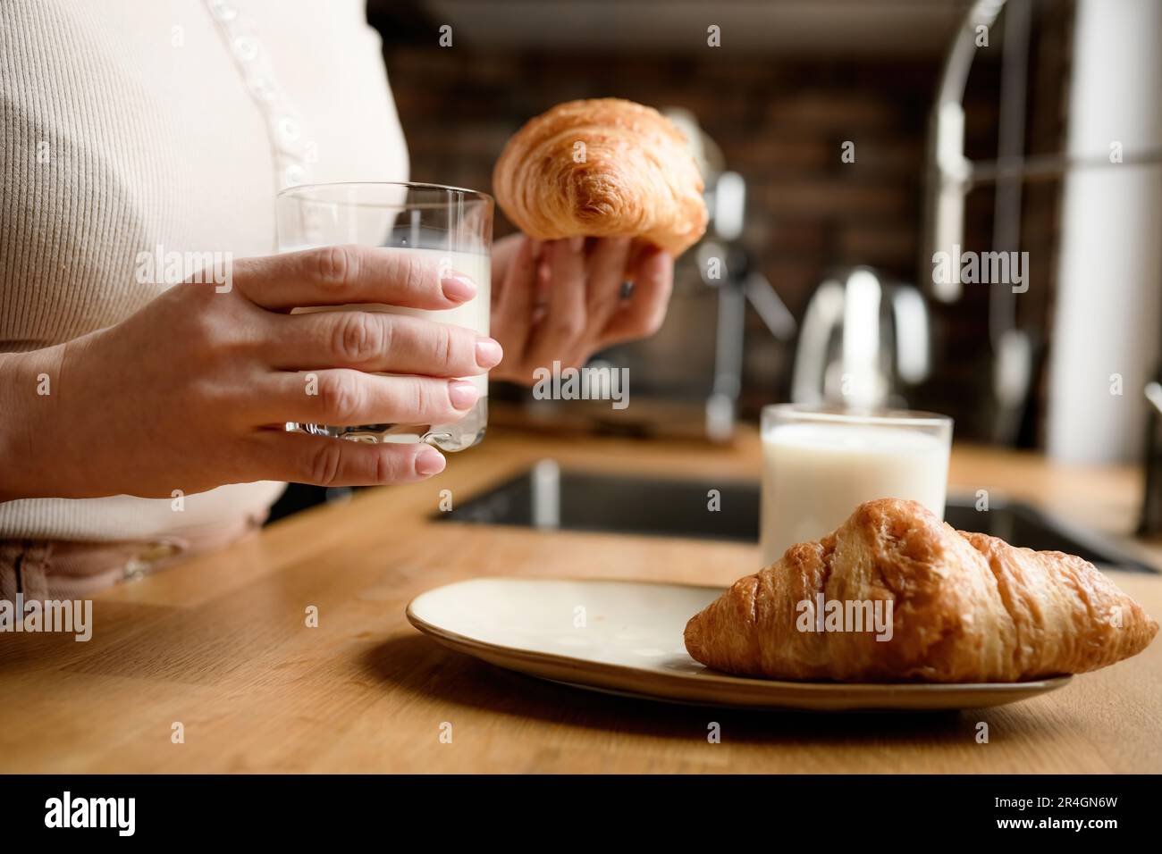 Girl has a breakfast with milk and croissants at kitchen Stock Photo ...