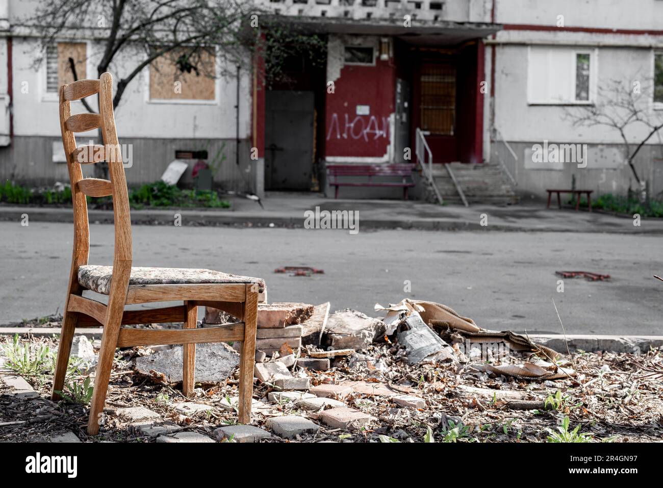 Abandoned chair and ruins near destroyed residential building with ...