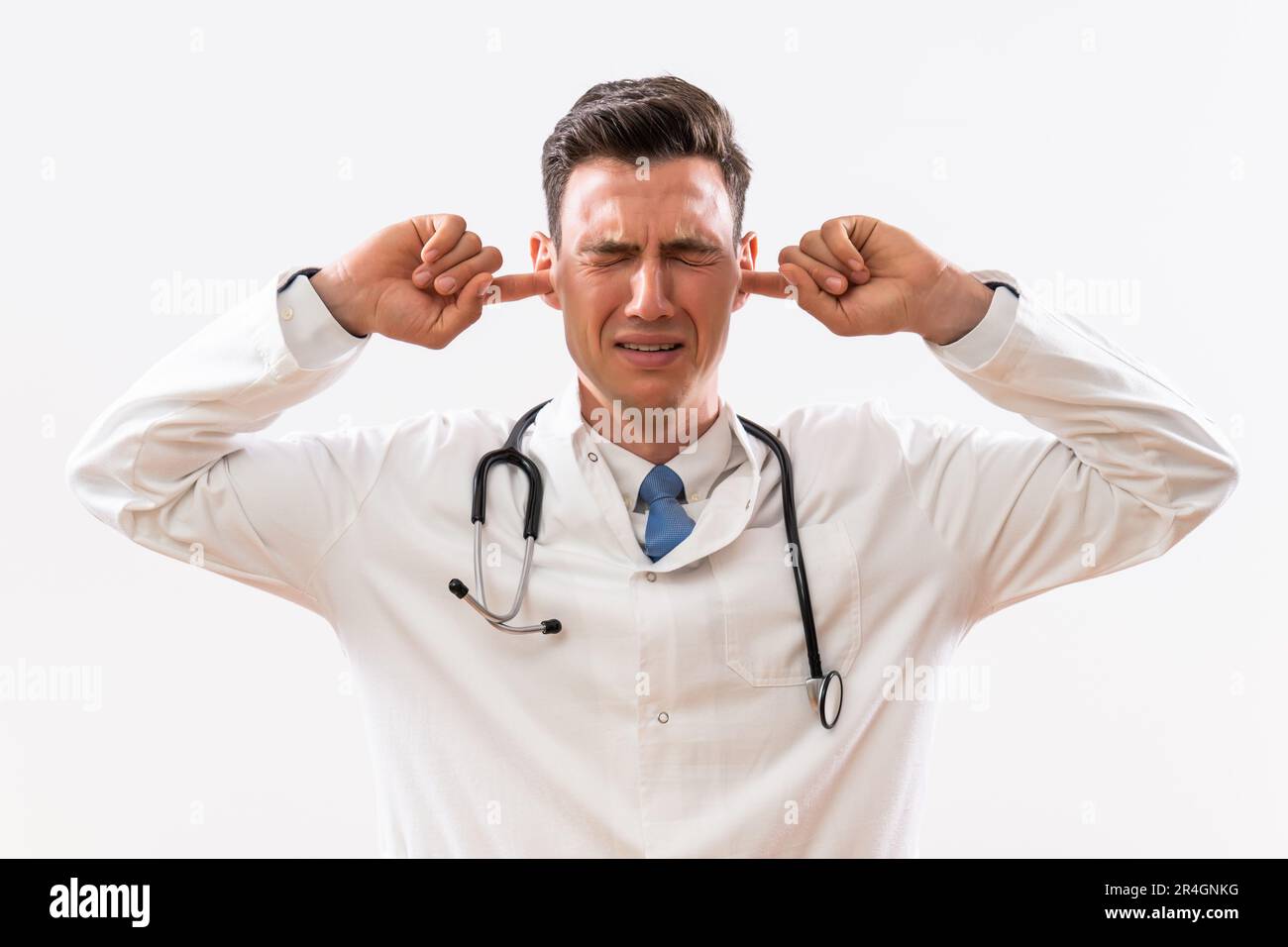 Image of overworked doctor with hands in ears Stock Photo - Alamy