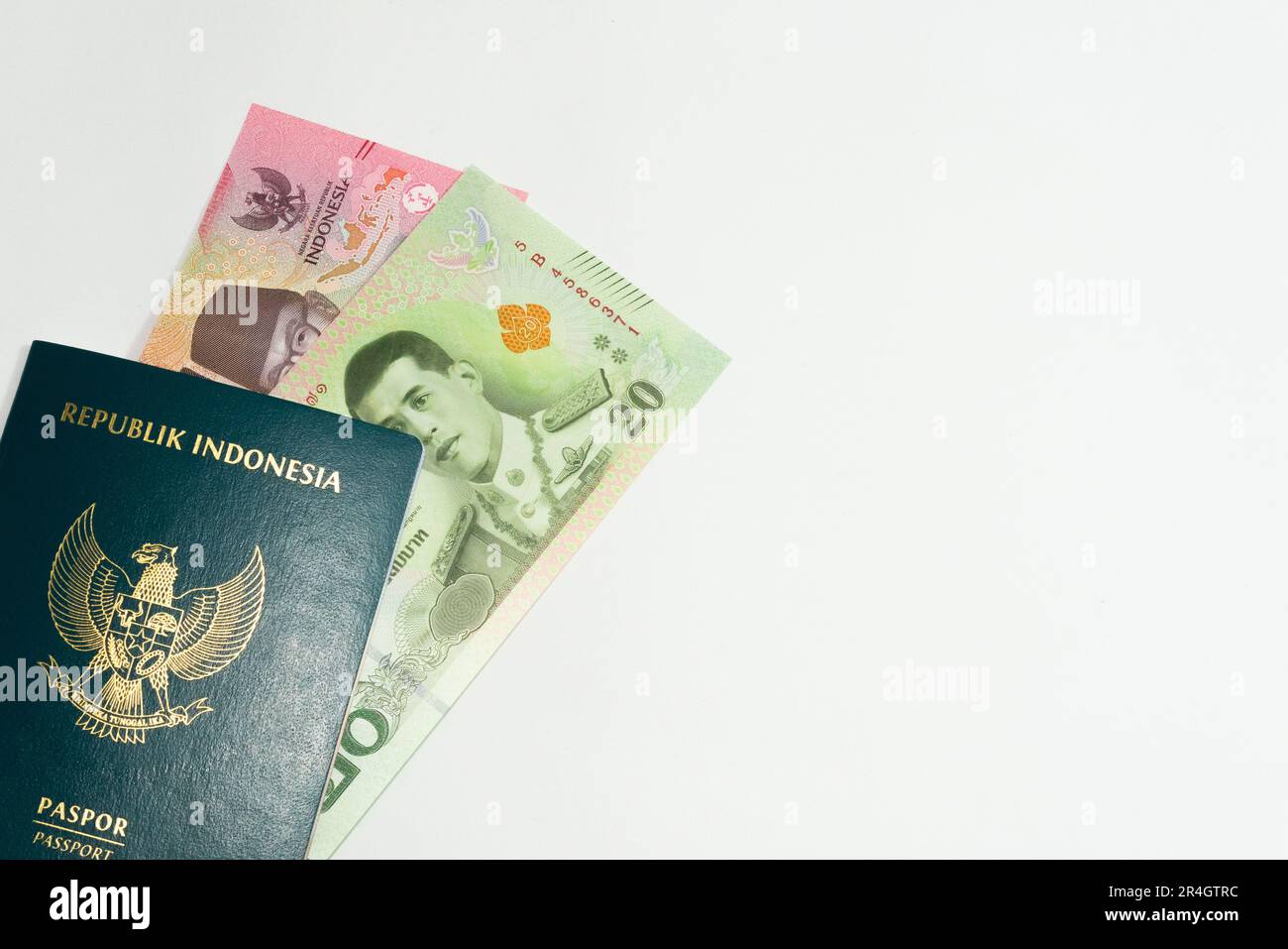 Indonesia passport, 100000 rupiah and 20 baht currency money on white ...