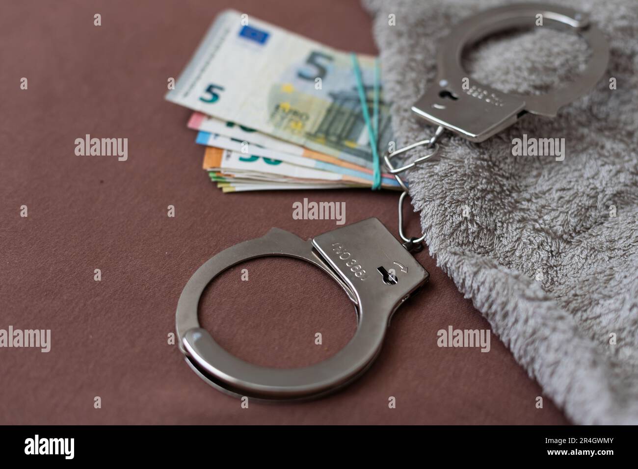Handcuffs - photo on money banknotes. Metal handcuffs are laying on ...