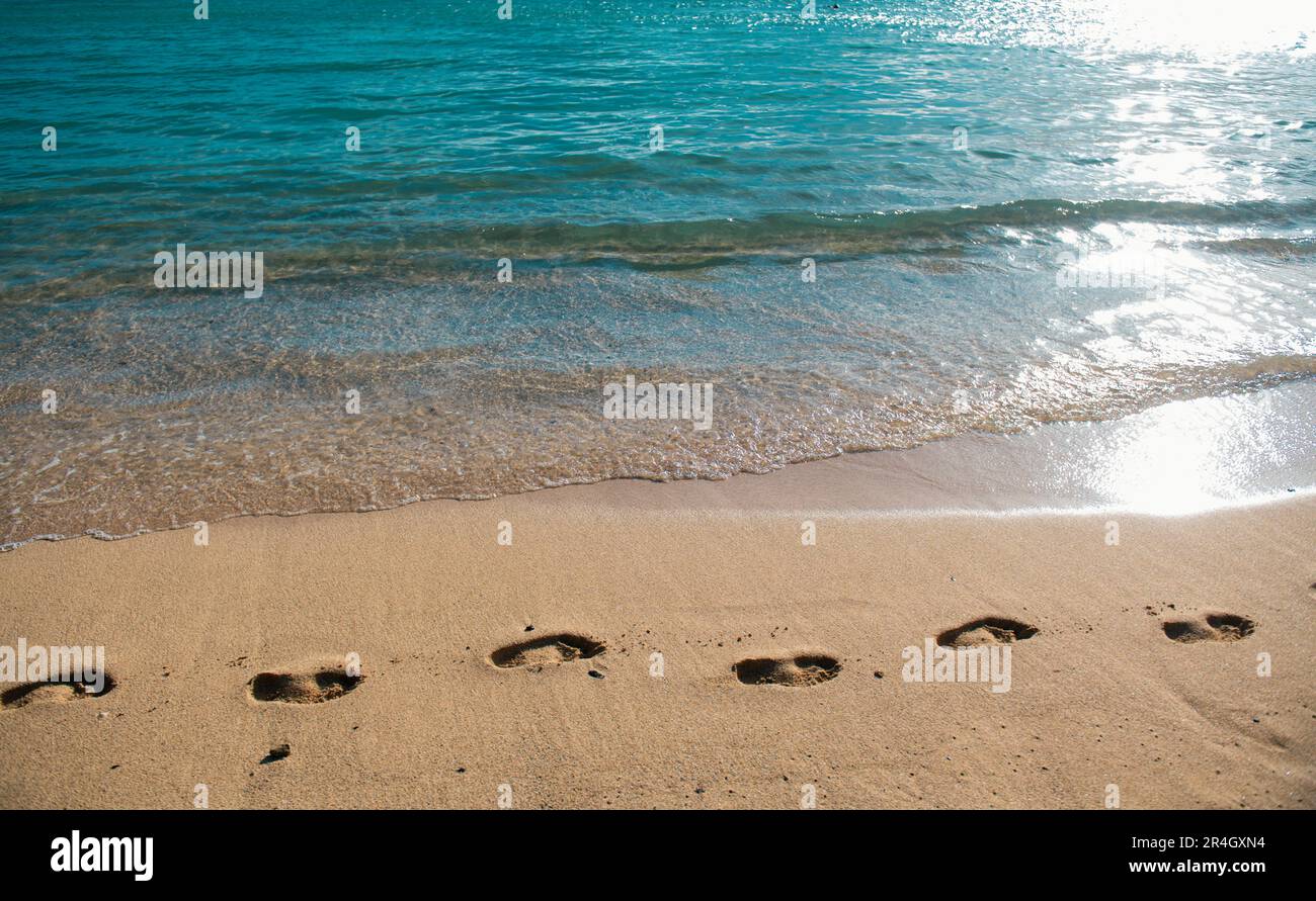 Footprints at golden sand, footsteps. Beach background. Calm beautiful ...