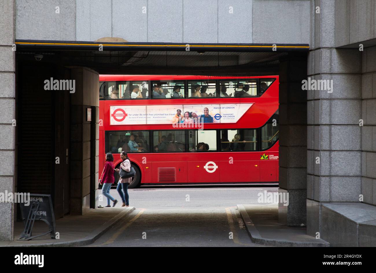 Red London bus on a city street with tourists Stock Photo - Alamy