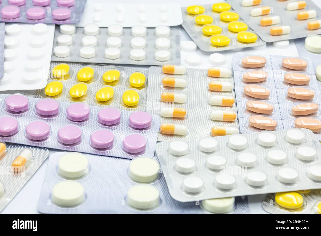 Pile of medical pills in Pink, white and yellow colors in silver ...