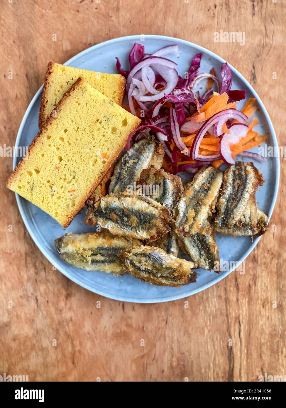 fried fish, top view delicious anchovy fish fry and corn bread on table ...