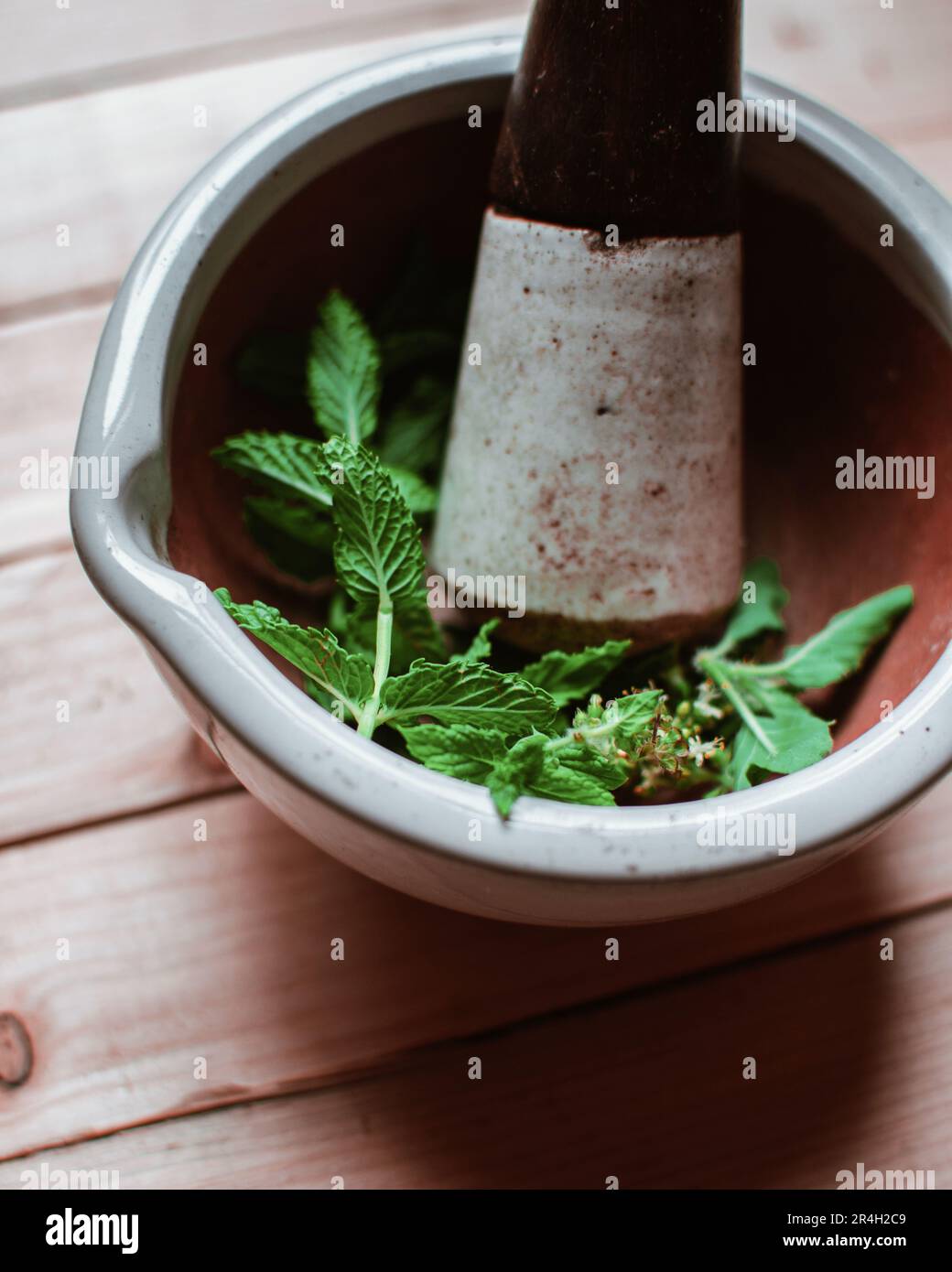 Basil in mortar and pestle Stock Photo - Alamy