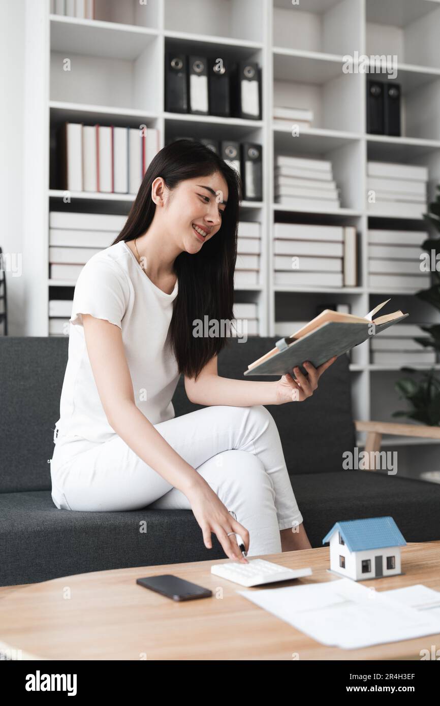 Asian accounting professional calculating household bills, reviewing ...