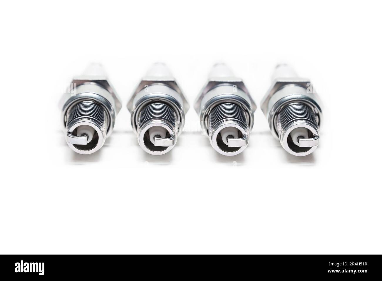 Four spark plugs on a white background, close-up Stock Photo - Alamy