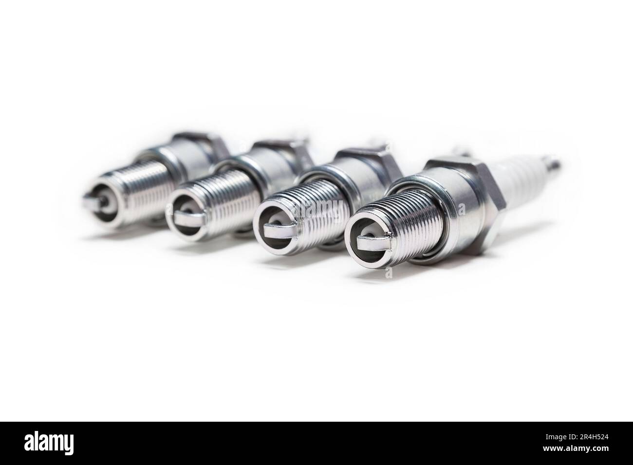 Four spark plugs on a white background, close-up Stock Photo - Alamy
