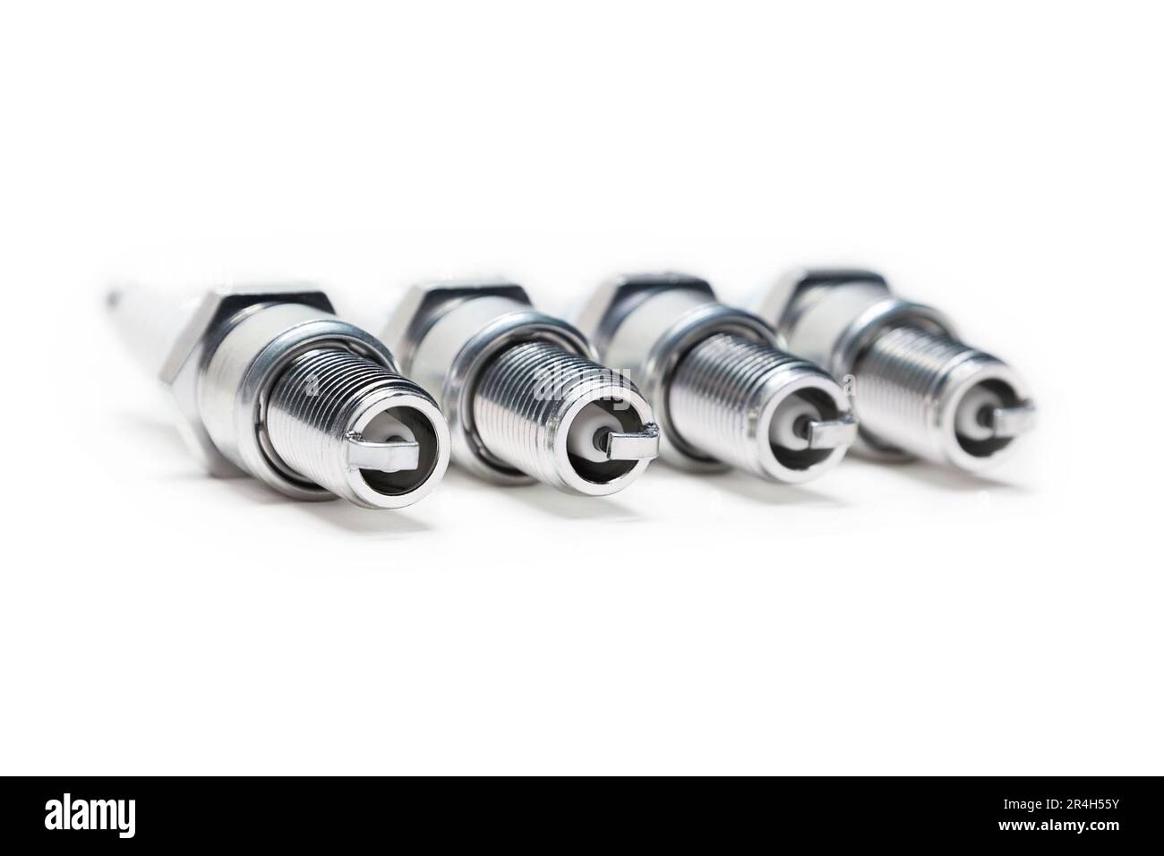 Four spark plugs on a white background, close-up Stock Photo - Alamy