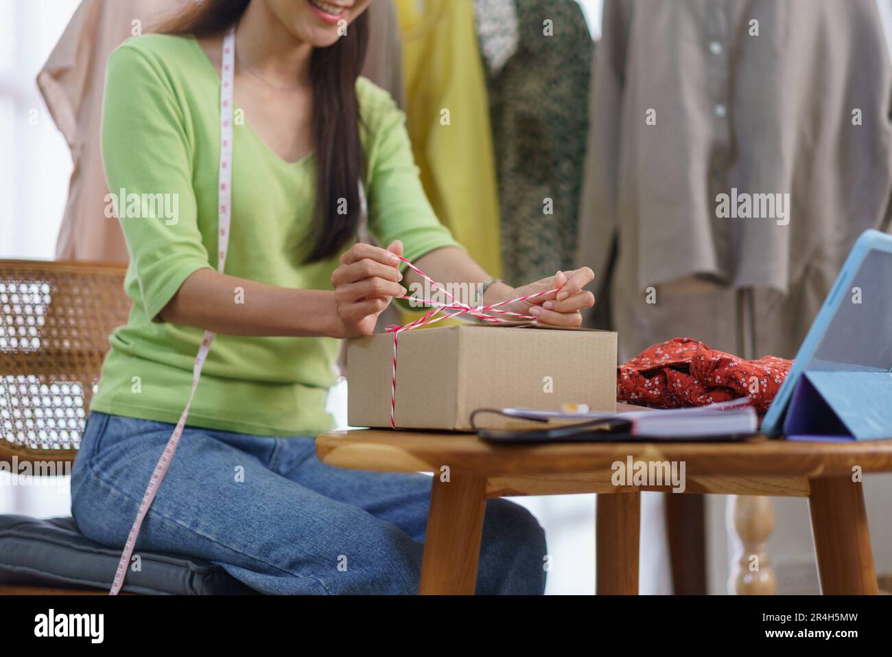 Fashion clothes merchant concept, Female seller packing product in ...