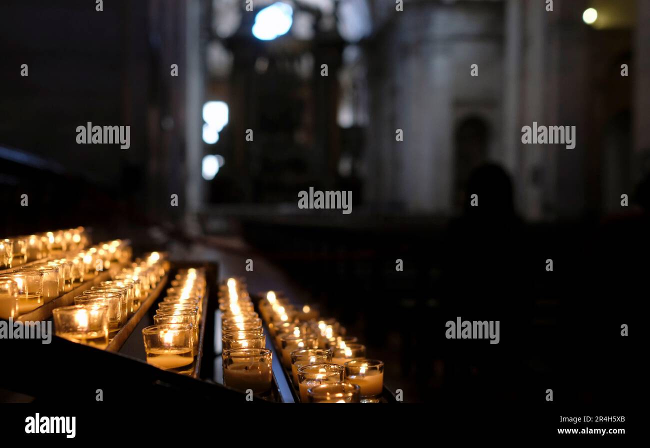 Many small candles illuminating a dark church room Stock Photo - Alamy