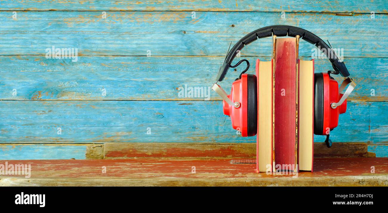 Audiobook concept with books and vintage headphones, wooden planks ...