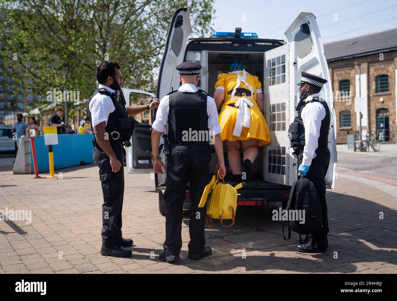 A person dressed as Pikachu is helped into a police van during MCM ...