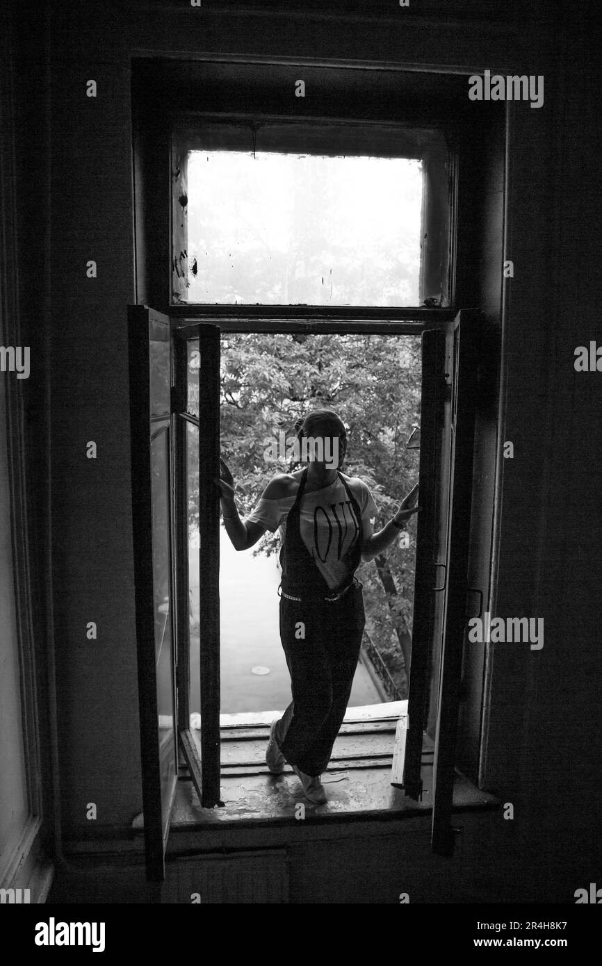 woman standing looking out the full long window Stock Photo - Alamy