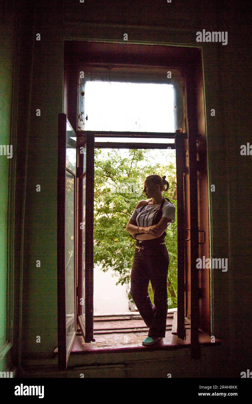 woman standing looking out the full long window Stock Photo - Alamy