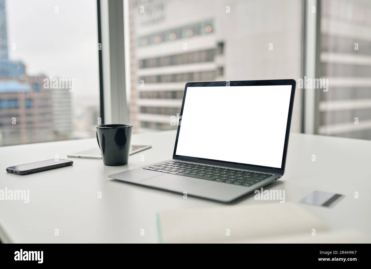 Laptop computer with white mock up empty blank screen on desk in office ...