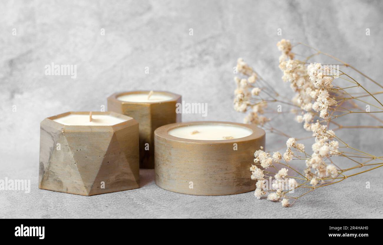 Scented candles in a pot on a concrete background. Soy wax candle and ...