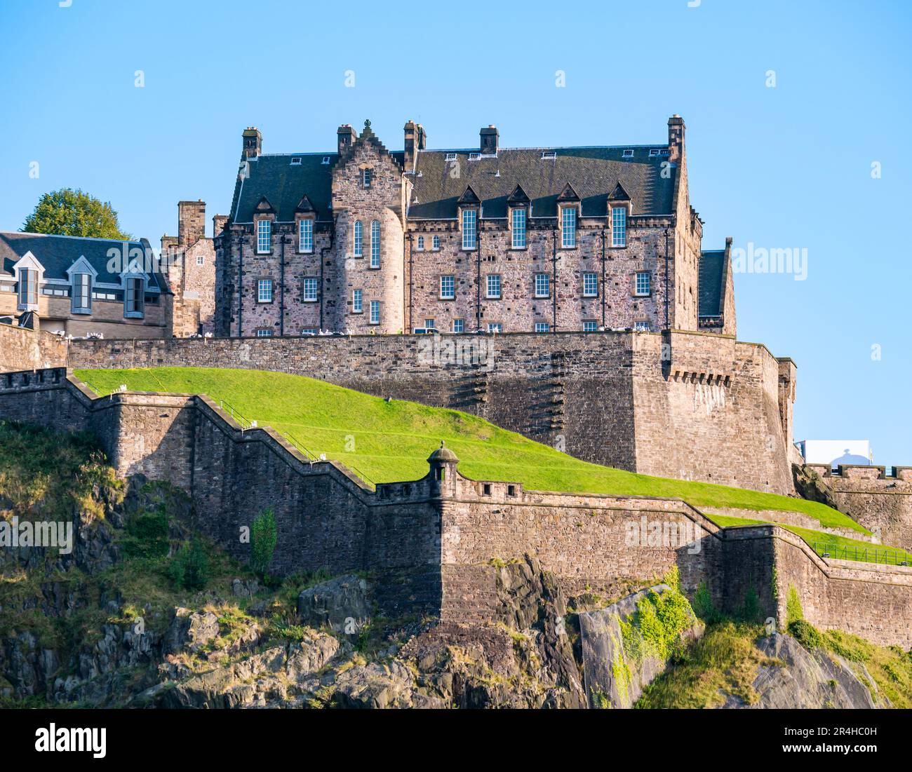 View of Edinburgh Castle building on rock outcrop with walls on cliff ...