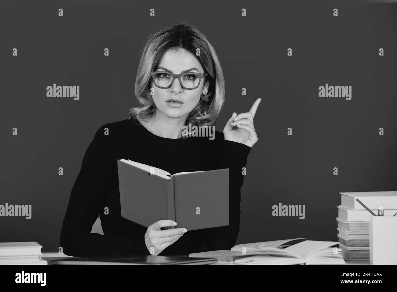 Portrait of teacher or female tutor working at table in college or high ...