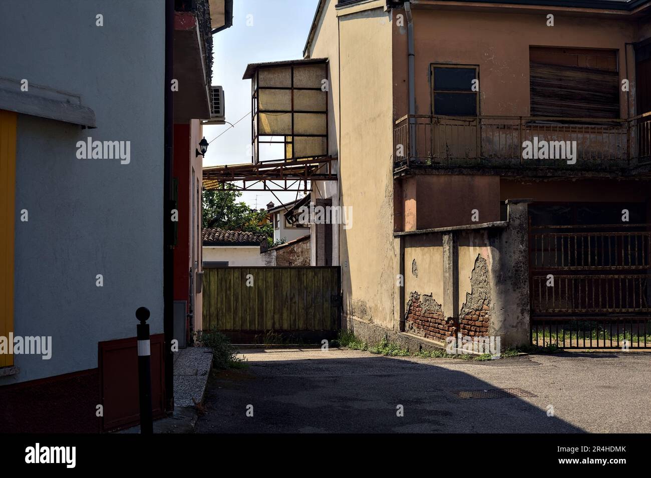 Abandoned warehouse blocked by gates in an alley on a sunny day in the ...